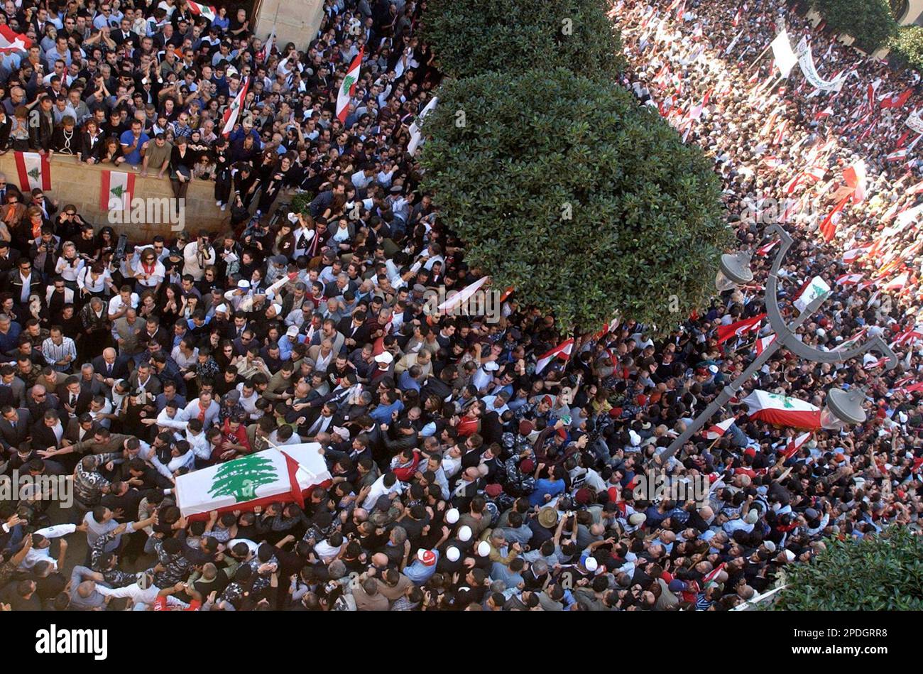 Lebanese mourners march while carrying the coffins of slain anti-Syrian ...