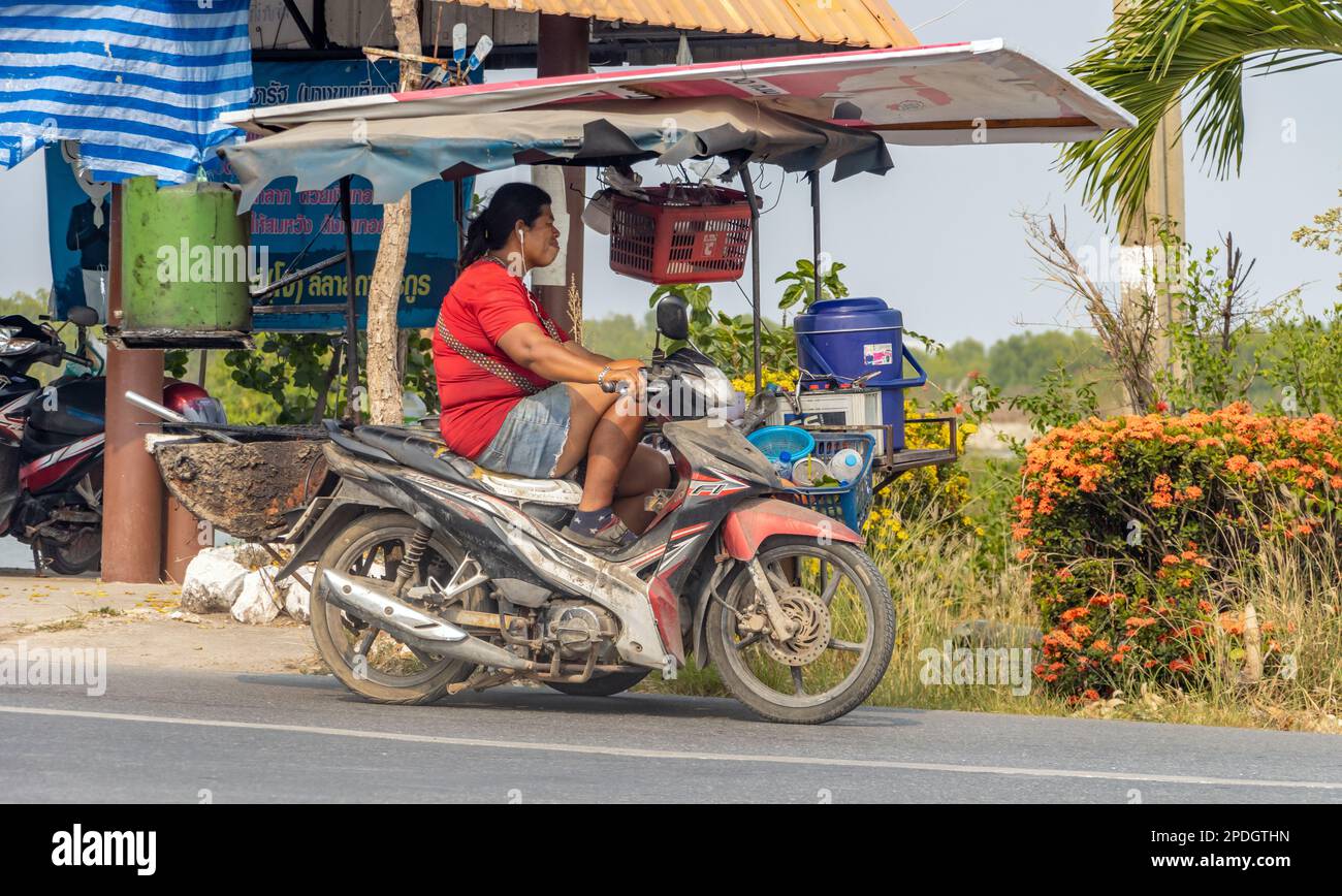 BANGKOK, THAILAND, MAR 11 2023, A woman drives a motorcycle with a ...