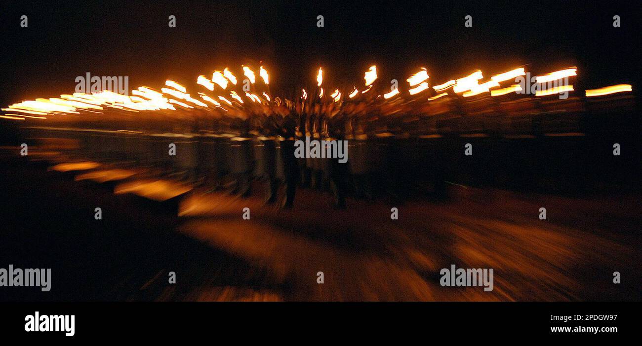 A zoomed photo shows German Army soldiers holding torches as they stand ...