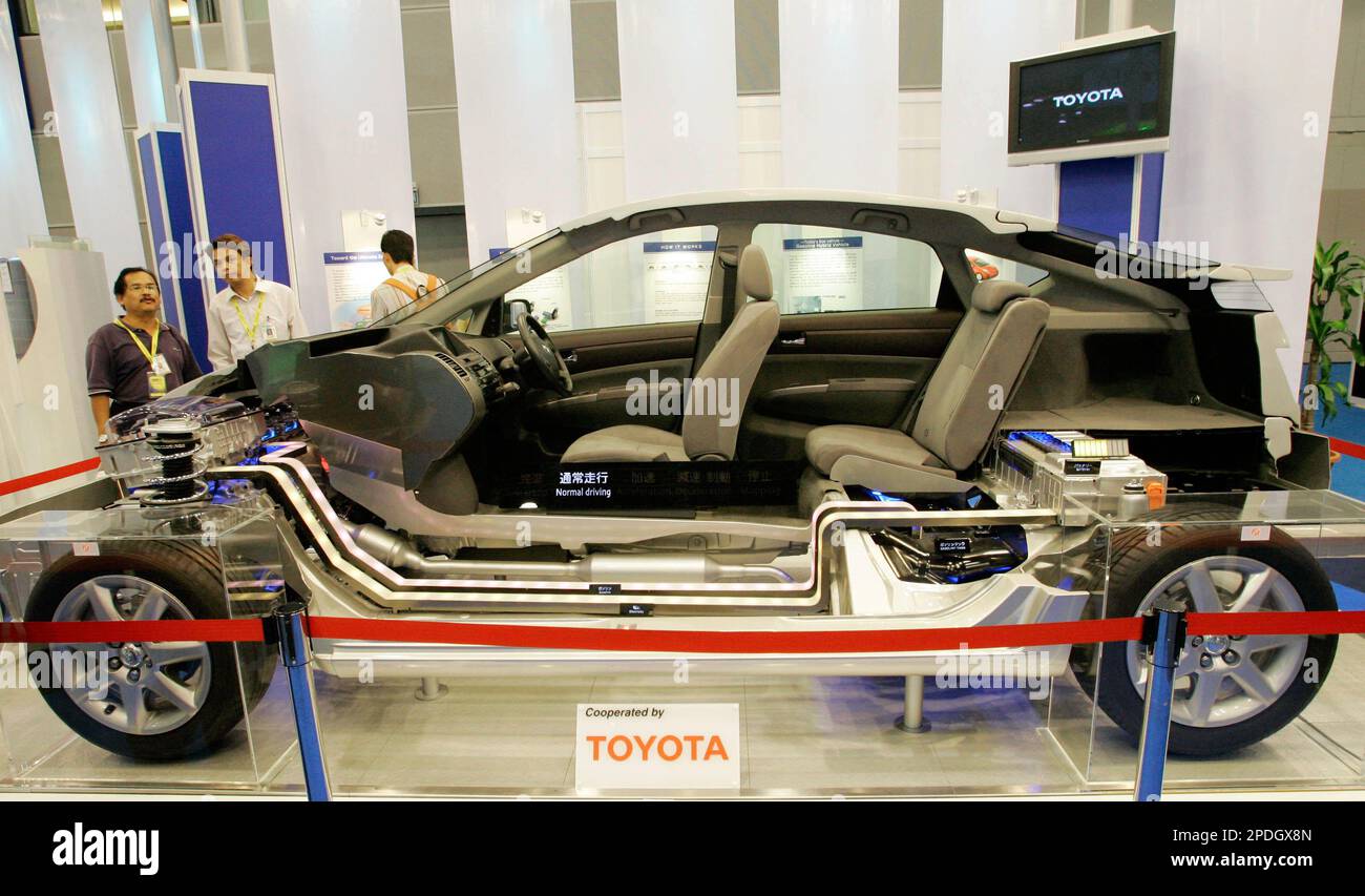 Visitors look at the Japanese motor Toyota Hybrid car on display at the ...
