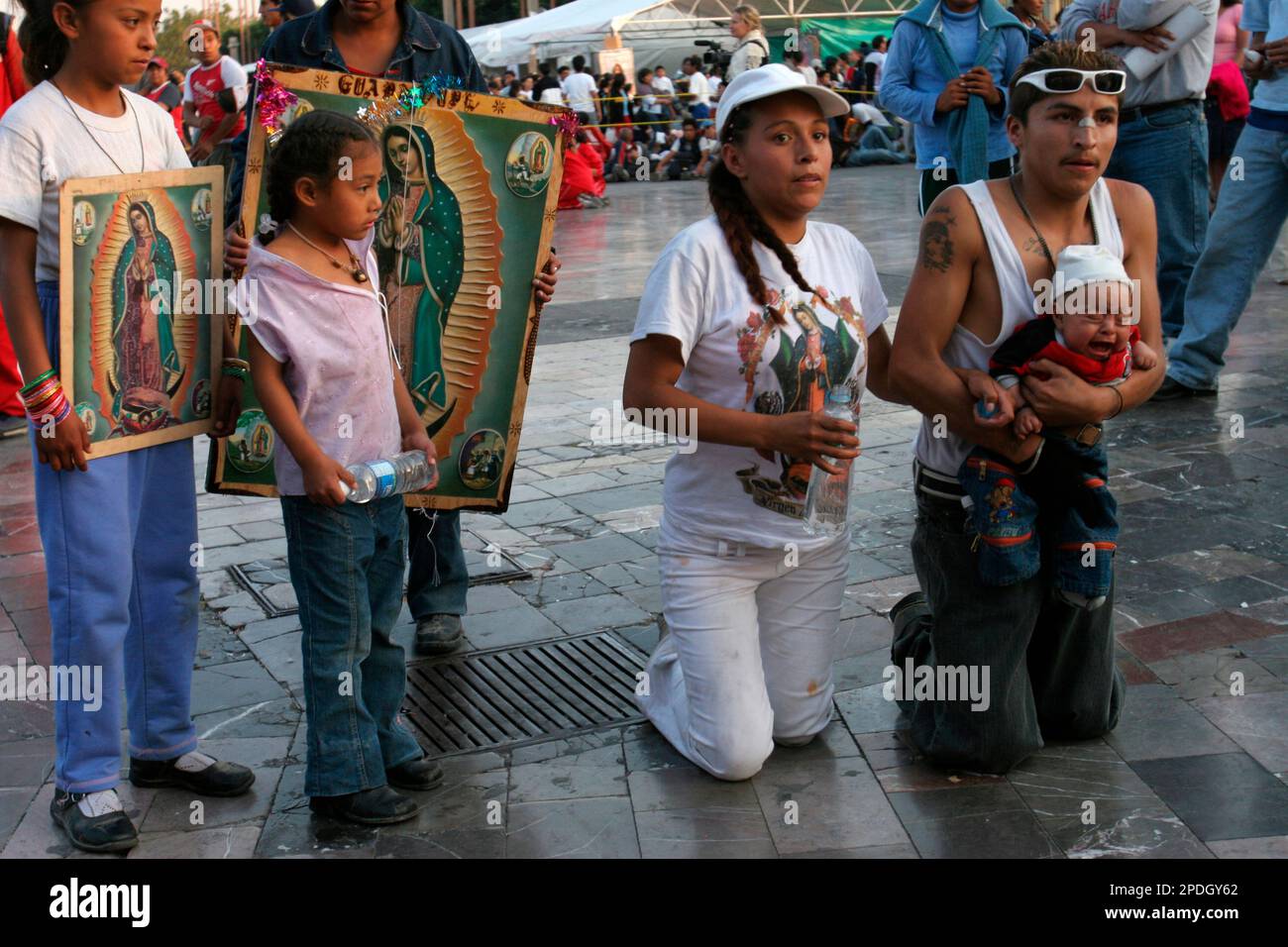 A family enters the Basilica of Guadalupe on their knees on the day ...