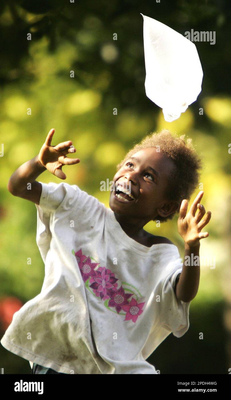 A young girl amuses herself with a simple inflated plastic bag at ...