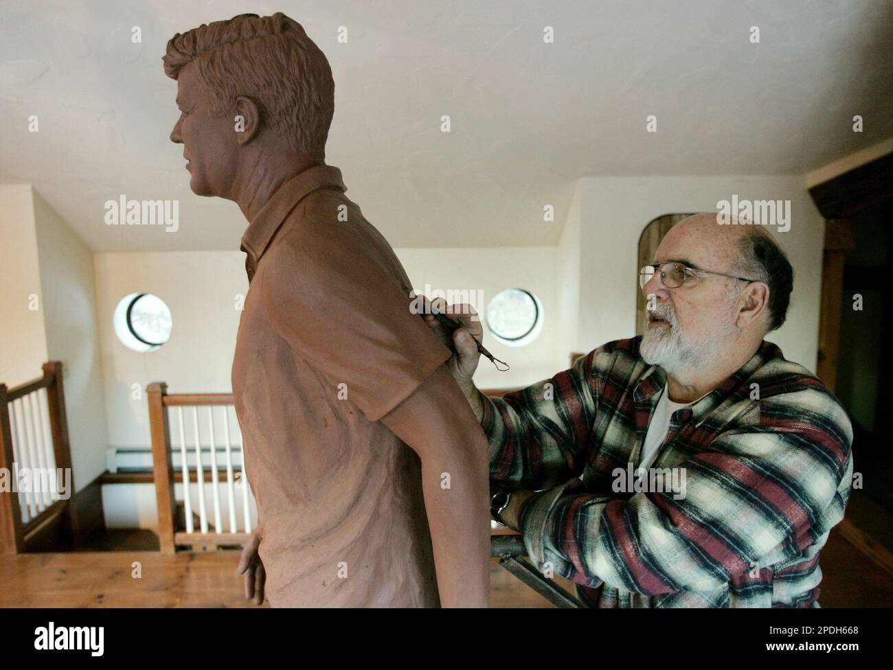 Sculptor David Lewis works on a nearly completed statue of former ...