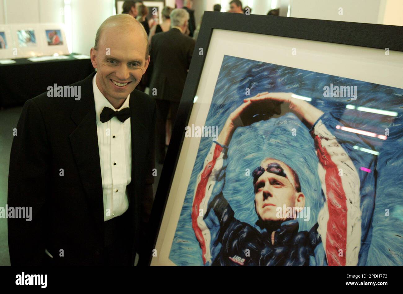 Olympic swimmer Rowdy Gaines stands next to a painting of himself ...