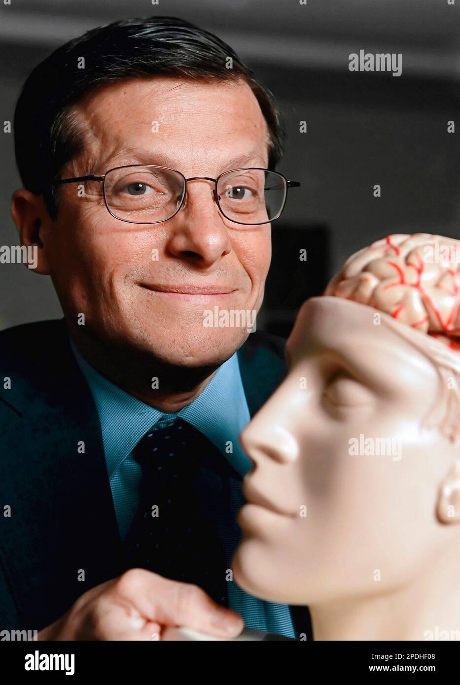 Dr. Michael F. Roizen holds a classroom model of the human brain in his ...