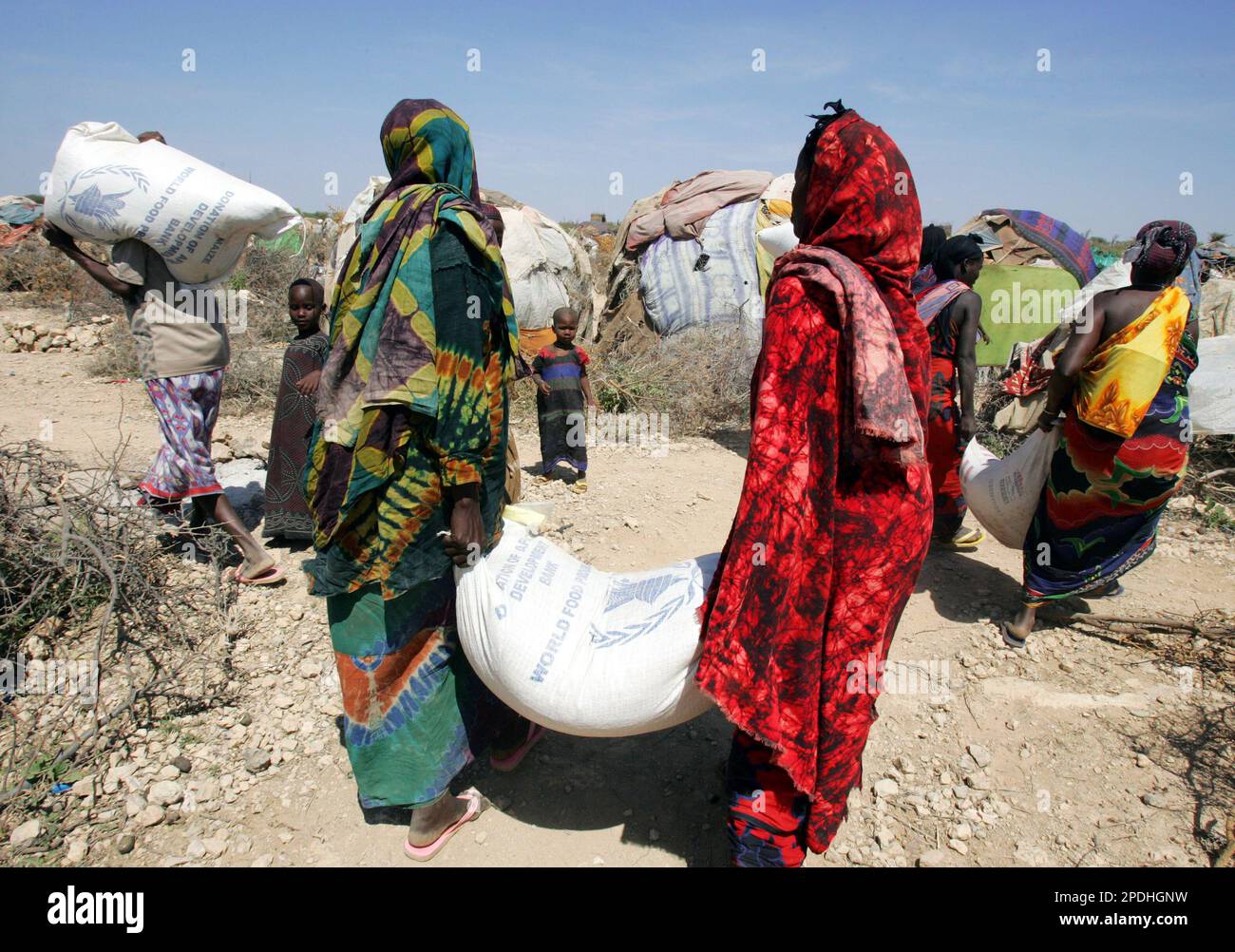 Internally displaced Somalis carry bags of maize donated by the World ...