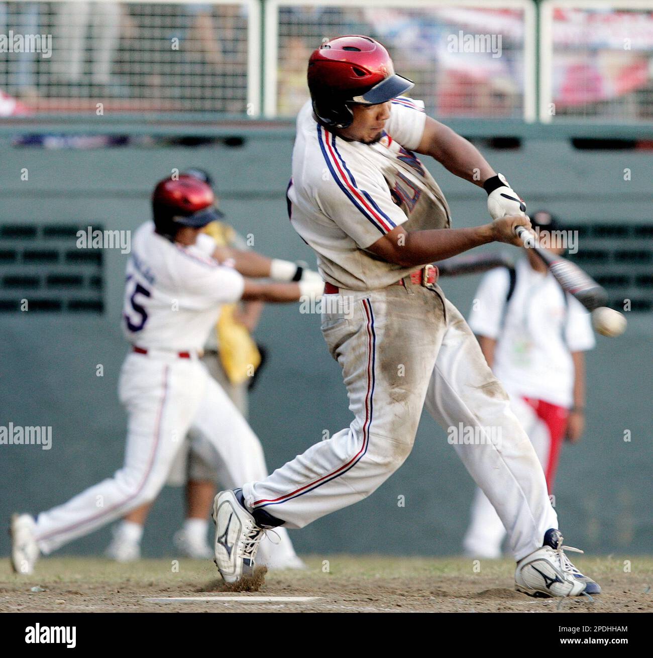 Nino Tator, 3rd base for the Philippines team, connects for a hit in ...