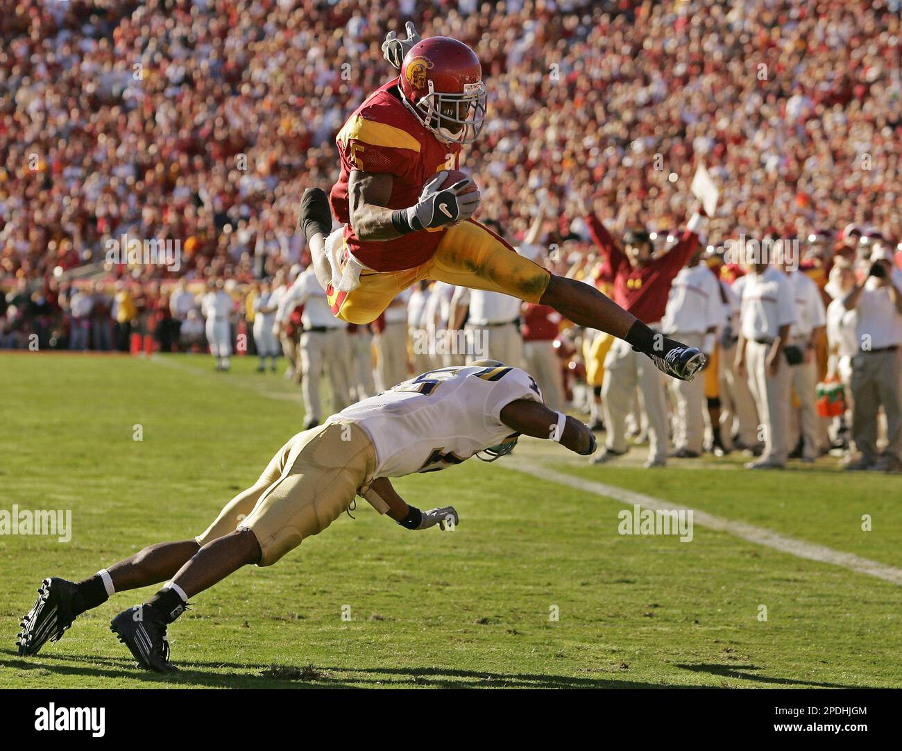 Southern California's Reggie Bush leaps over UCLA defender Marcus ...