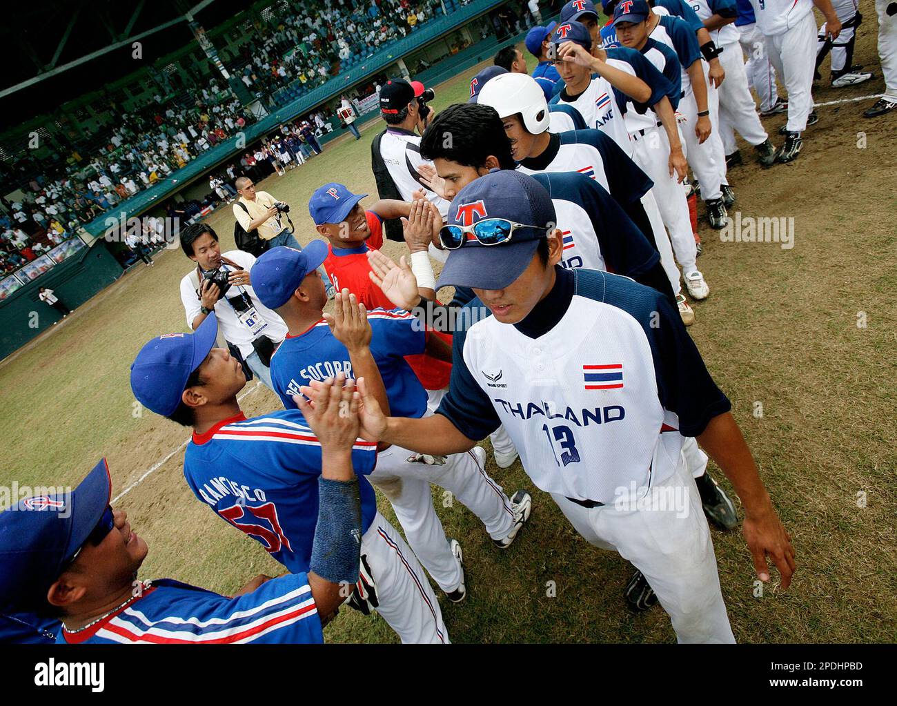 Philippine baseball team, left is congradulated by Thailand's team ...