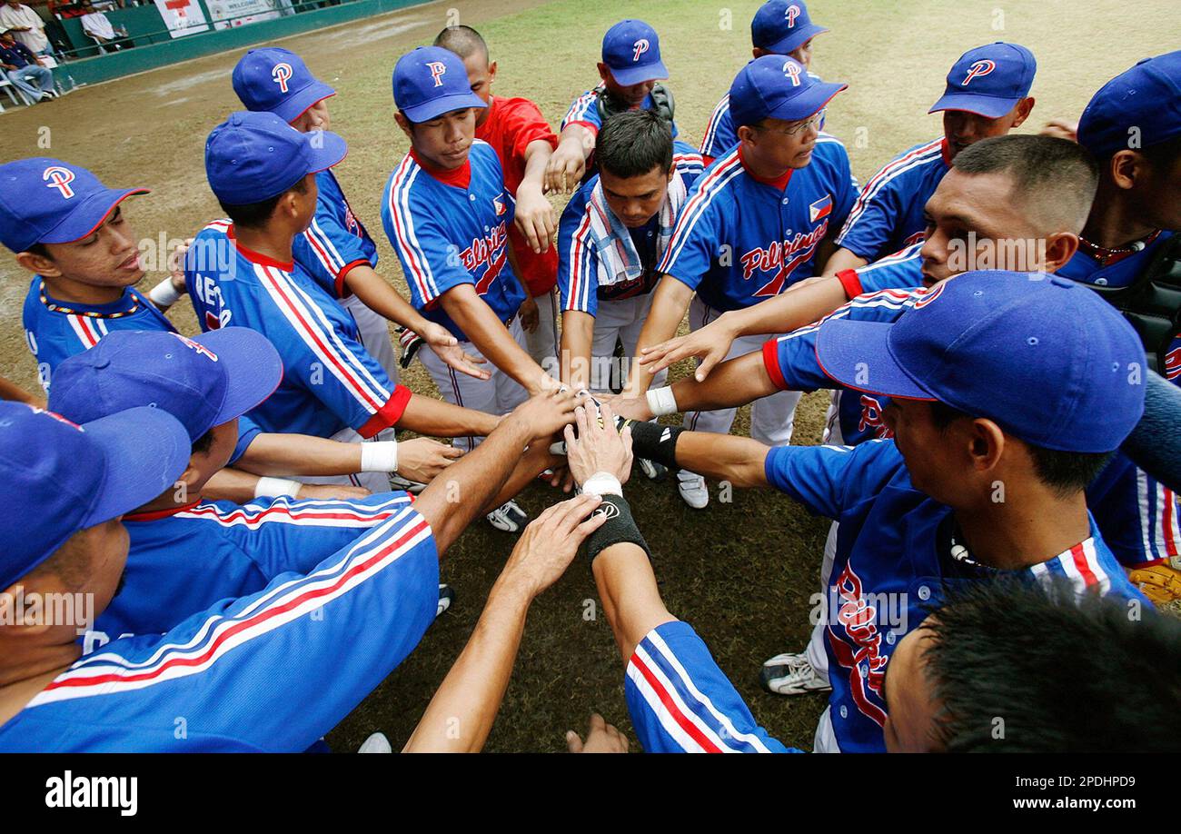 The Philippine baseball team put their hands together as a symbol of ...