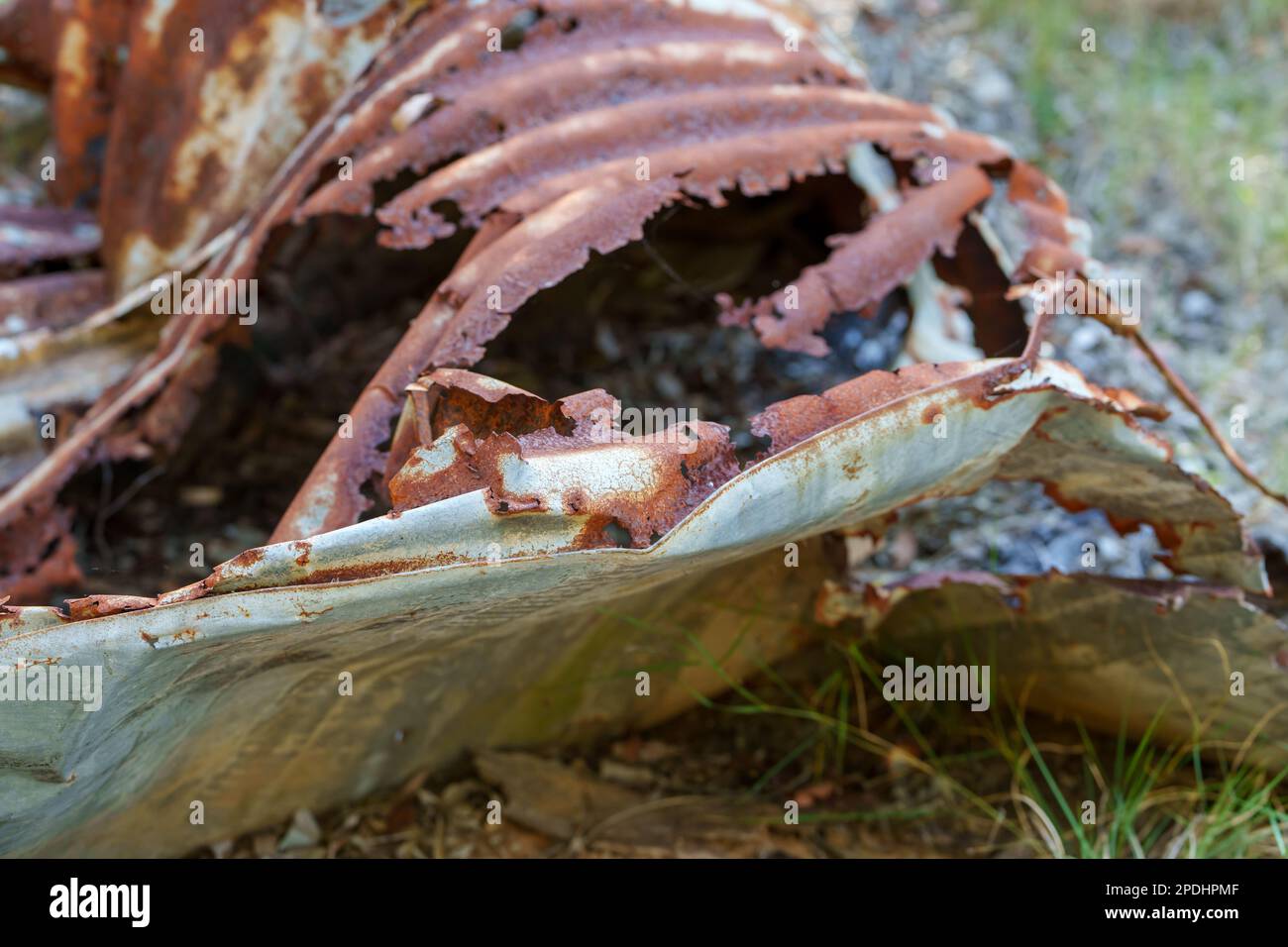 Rusted and decayed, old corrugated iron watertank lying on the ground ...