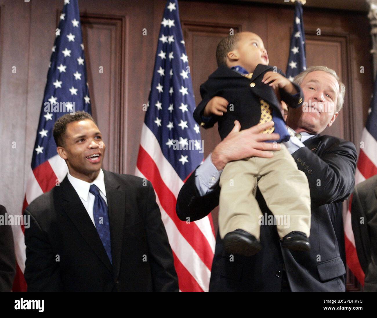President Bush picks up 2 year-old Jesse Jackson III after signing a ...