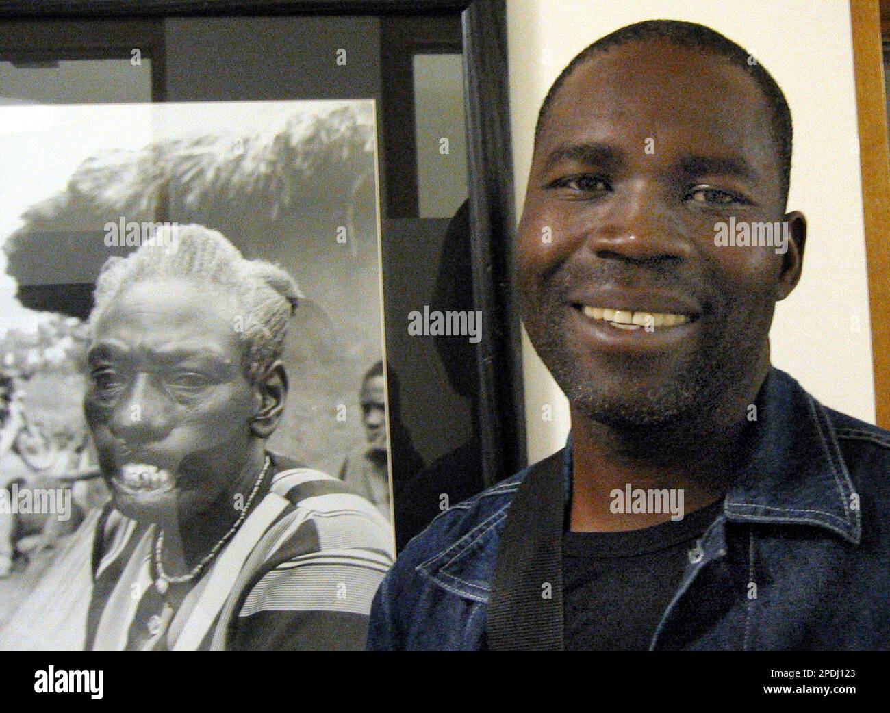 Ugandan photographer James Akena poses at the London opening of his ...