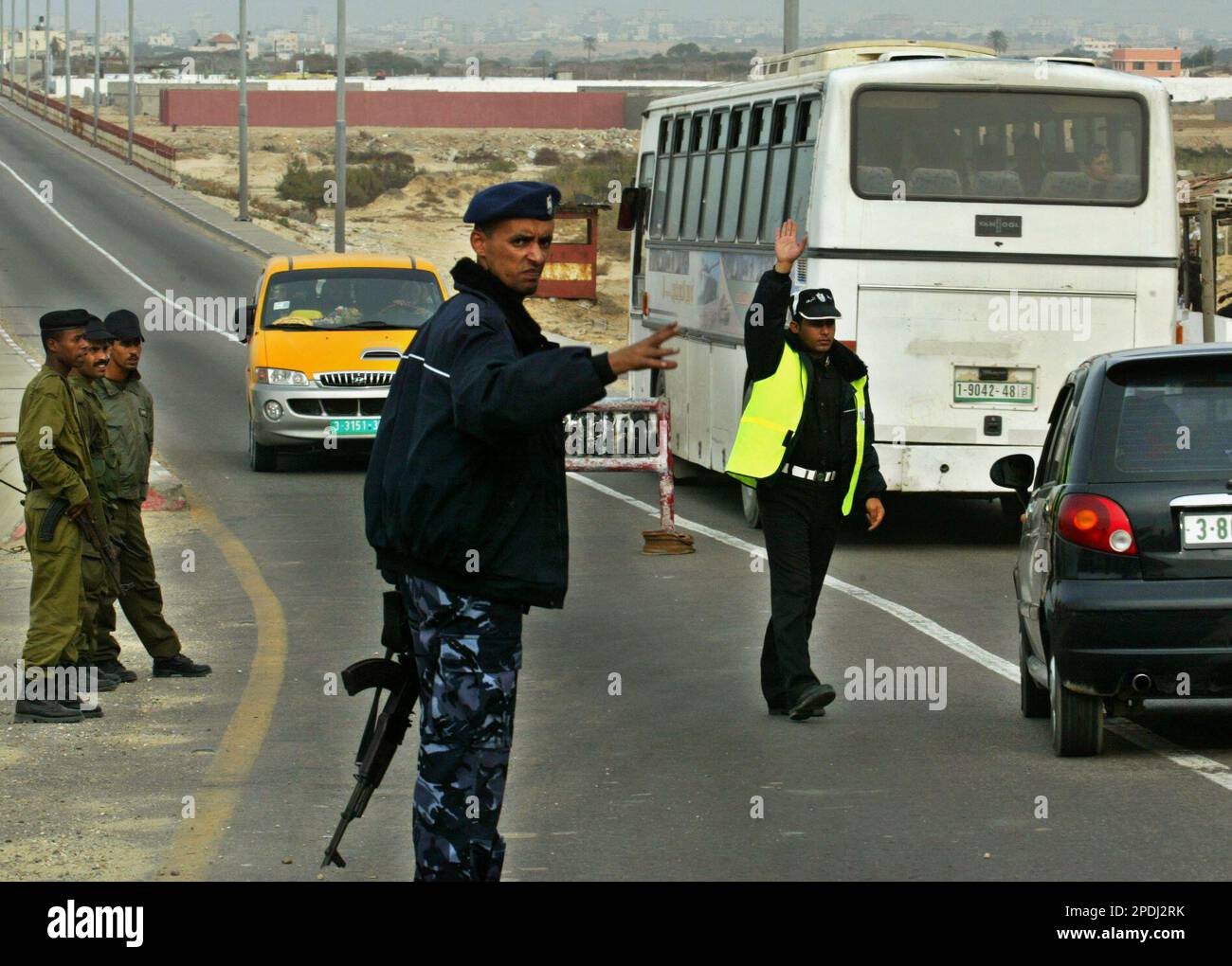 Palestinian police officers direct cars to stop for a security check at ...