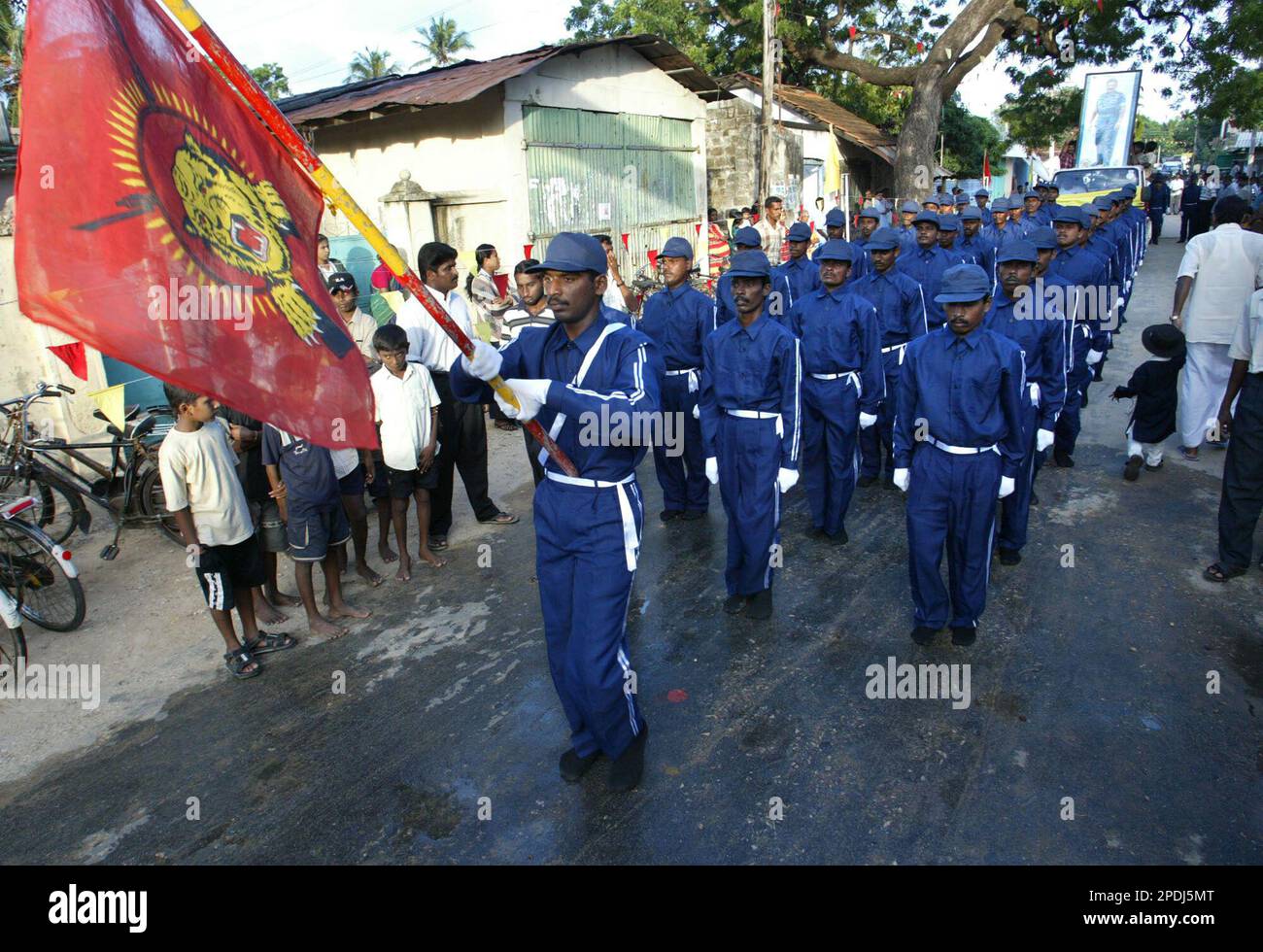 Tamil youths, members of a rebel volunteer force march with a flag of ...