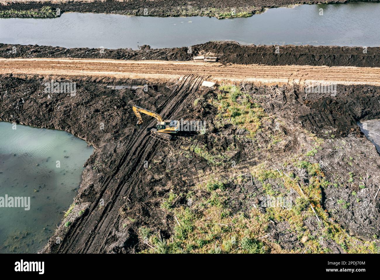 large yellow backhoe digs a reclamation ditch. land improvement. aerial ...