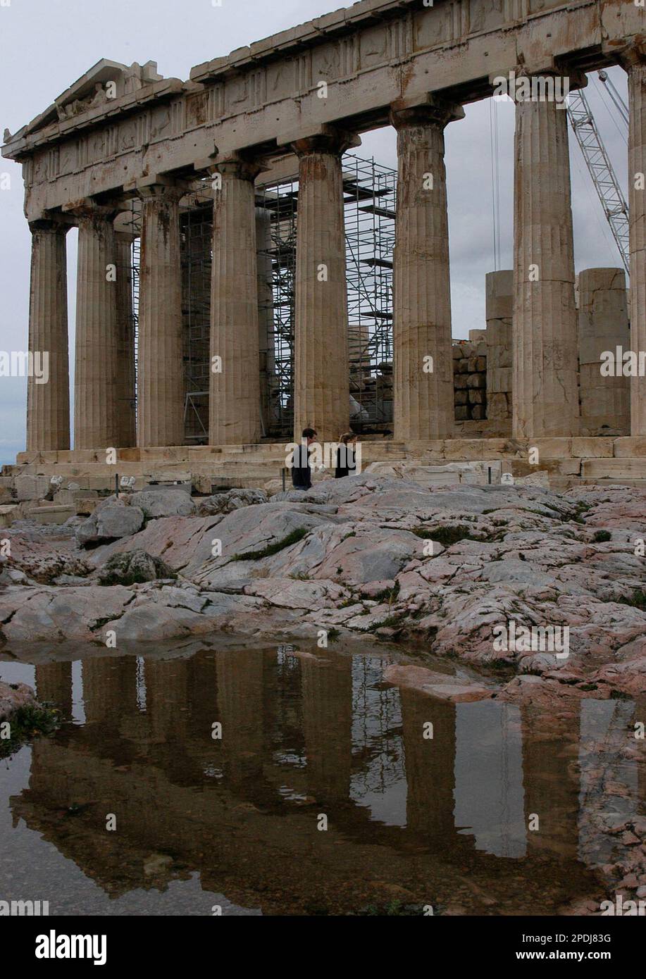 The ancient Parthenon monument is reflected in a puddle following heavy ...