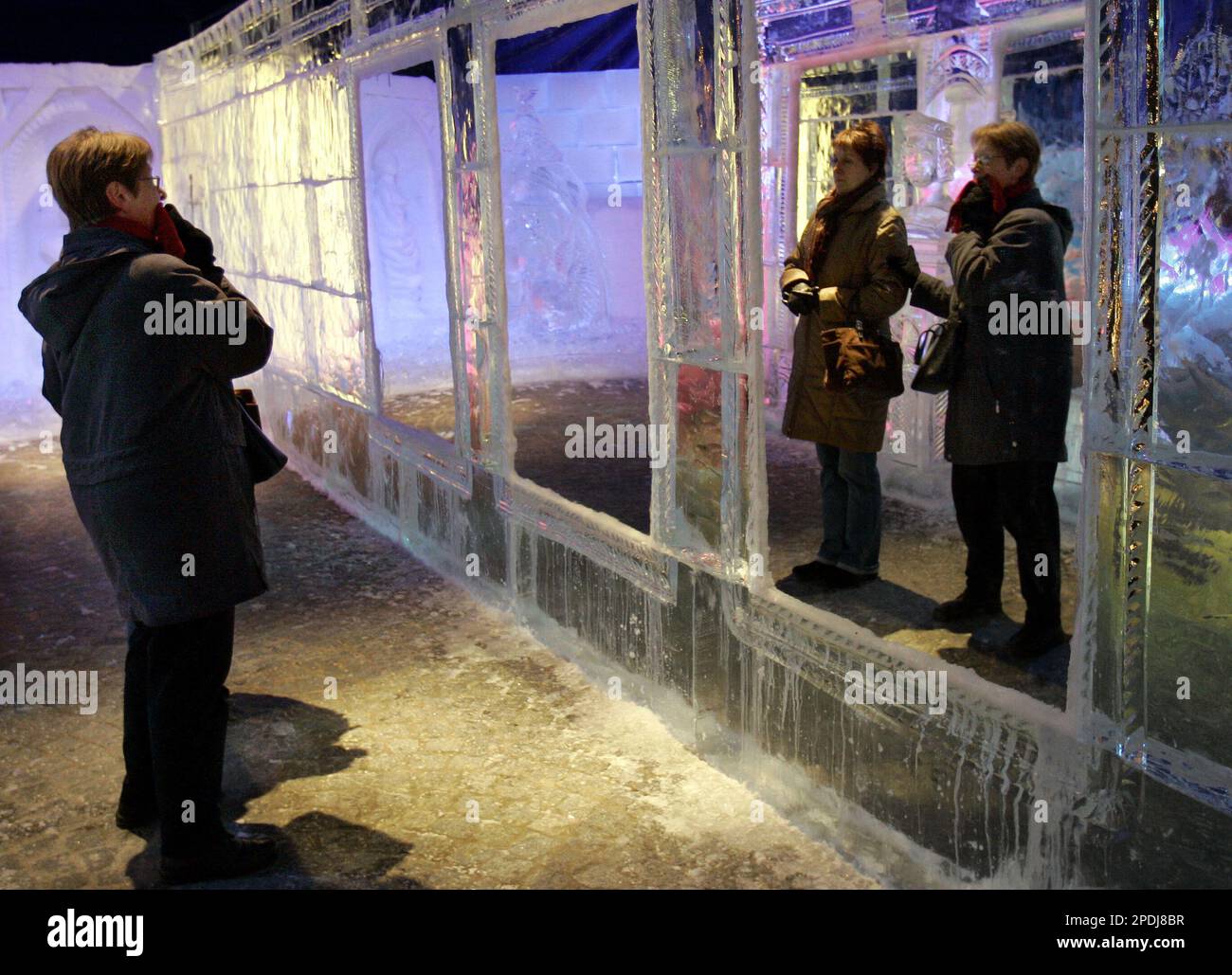 Visitors are reflected in a mirror surrounded by ice at the Snow and ...
