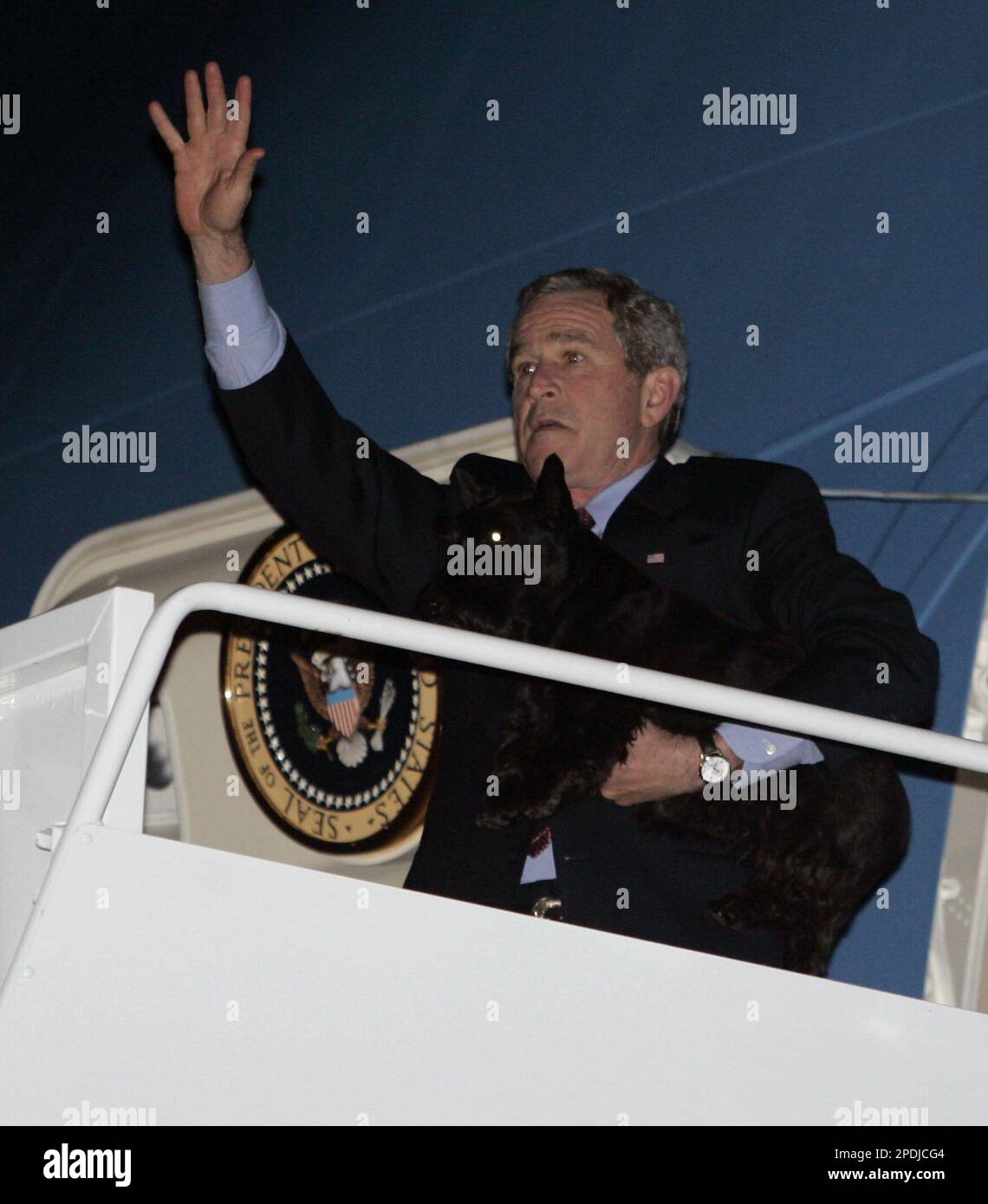 President Bush holds his dog Barney as he waves to a crowd after ...