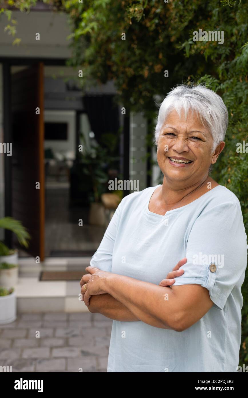 Cheerful Biracial Senior Woman With Short Gray Hair Crossing Arms And