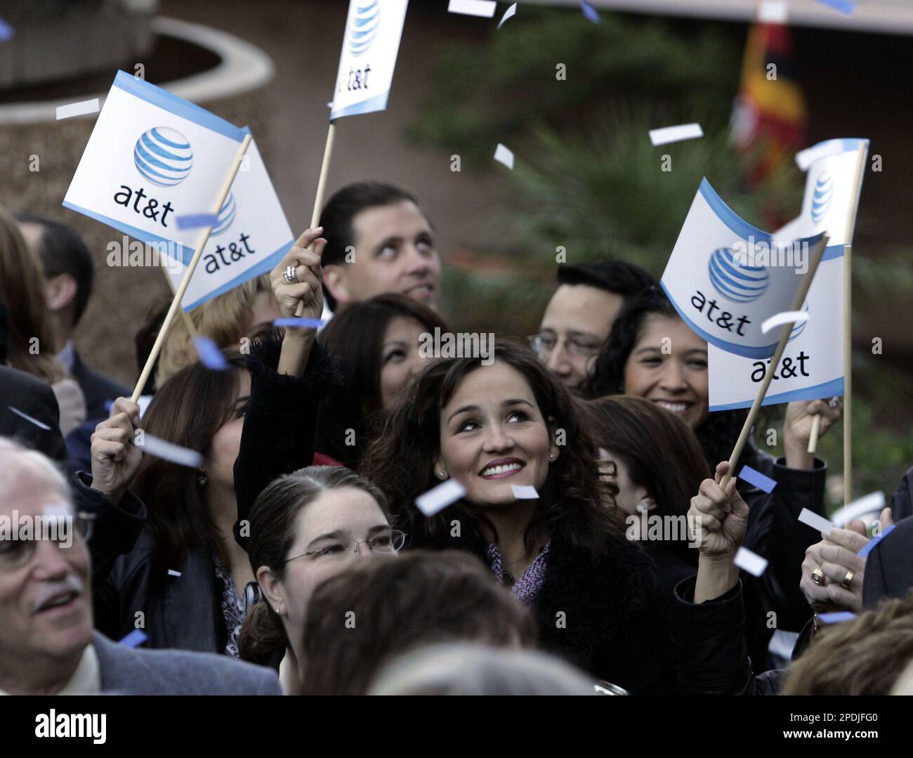 Employees wave flags as the new AT&T Corp. logo is unveiled at the ...