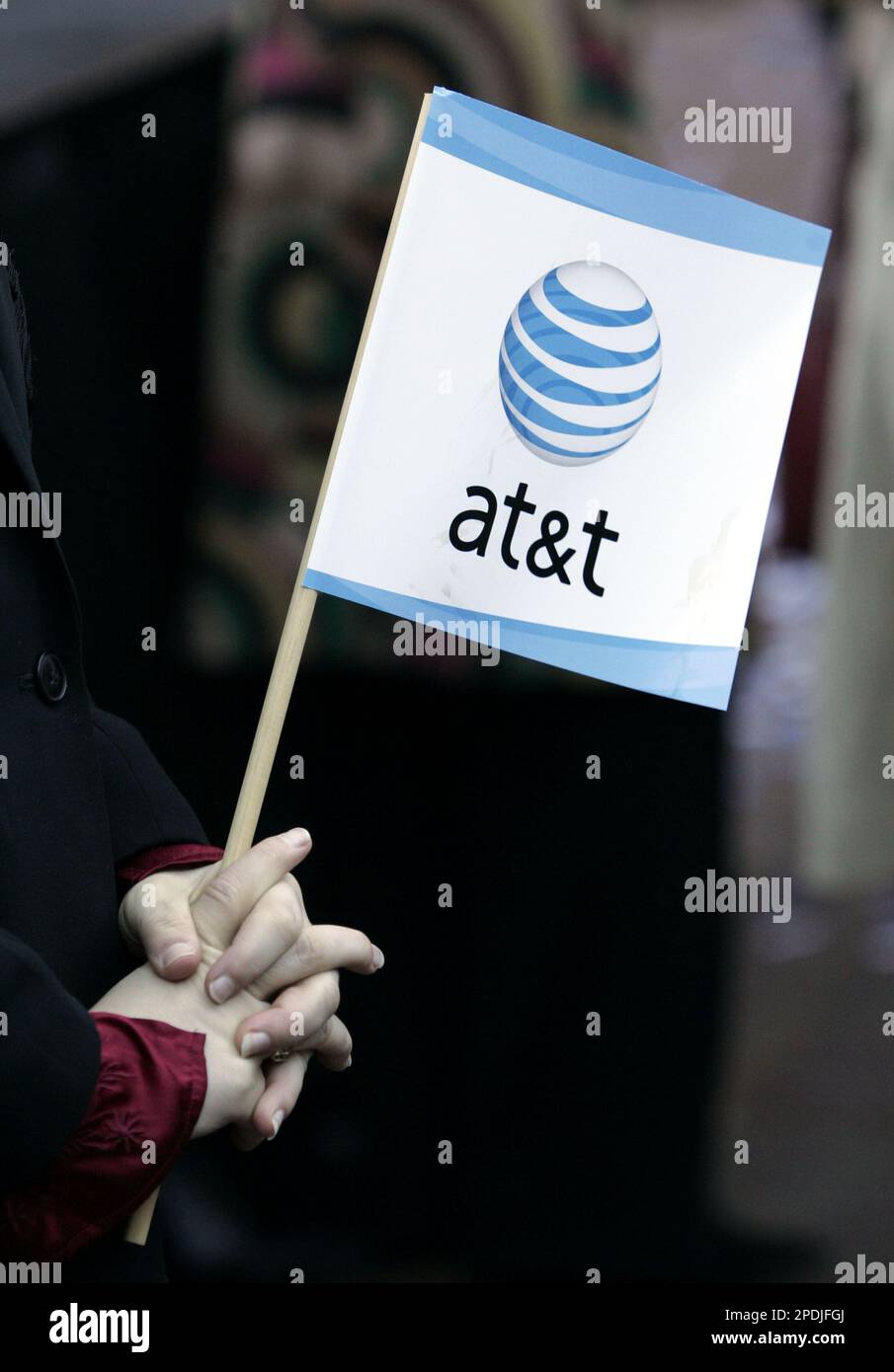 An AT&T employee holds a banner showing the new AT&T Corp. logo during ...