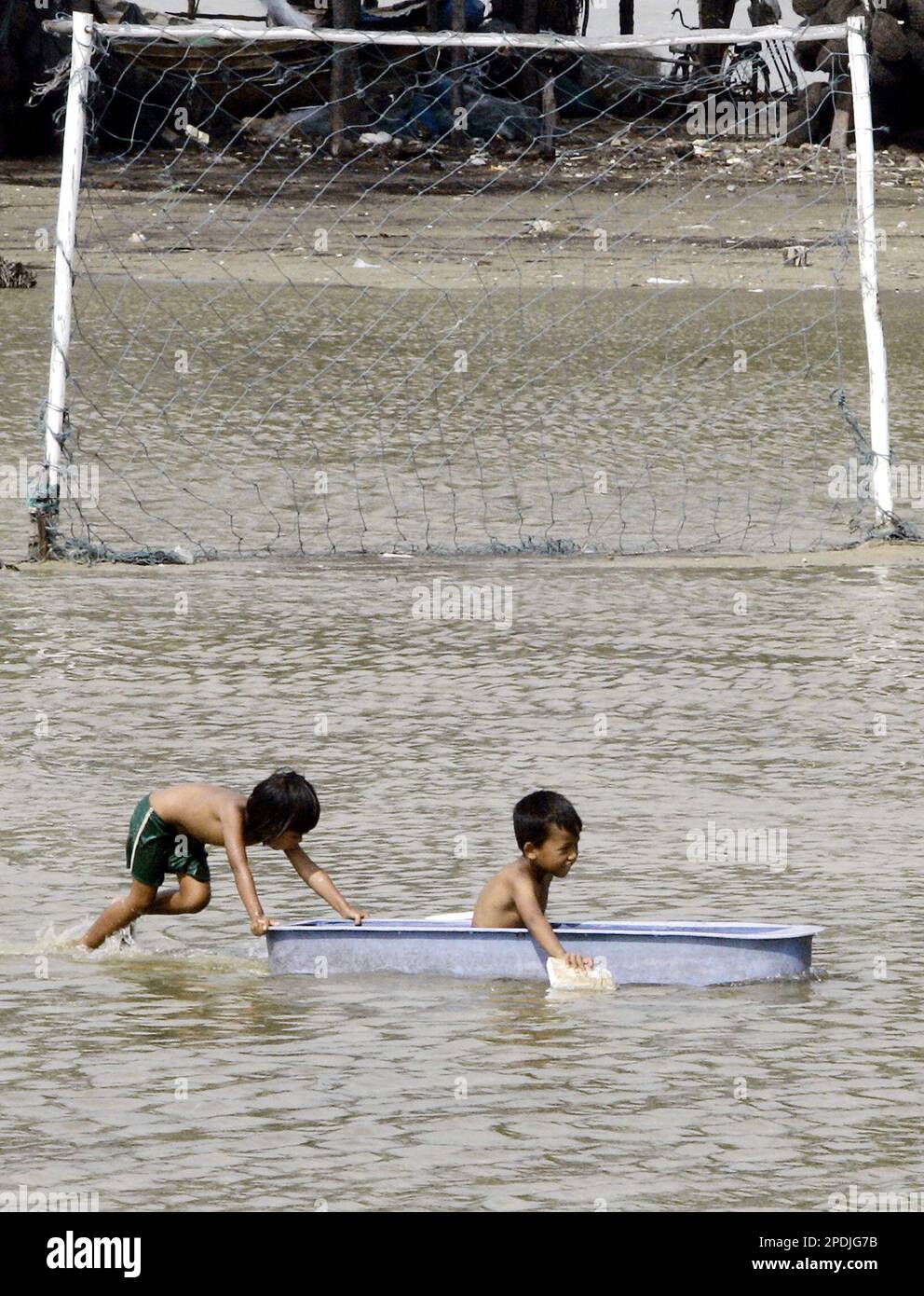 Two children play at a flooded soccer field in Pattani province ...