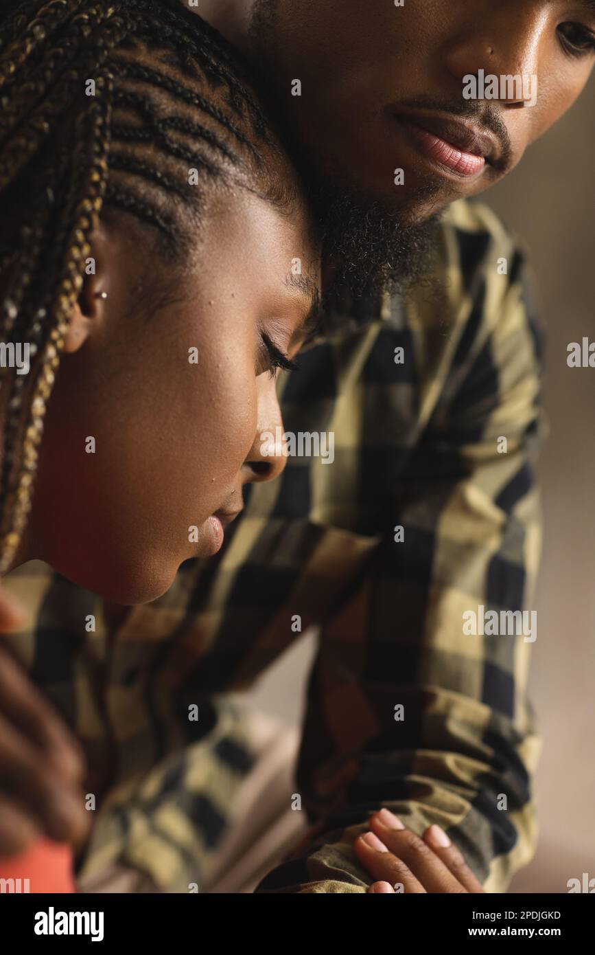 Sad african american couple sitting and embracing in hall Stock Photo ...