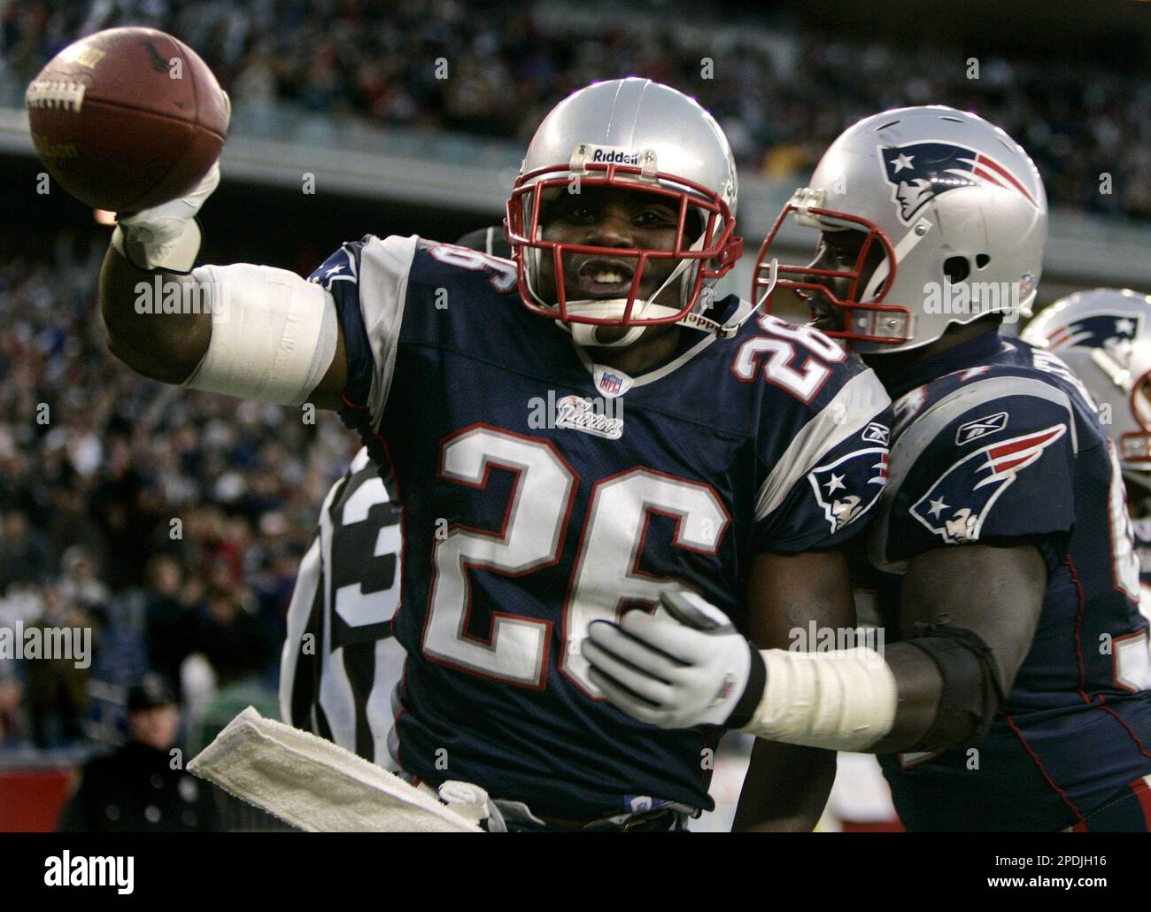 New England Patriots defensive back Eugene Wilson holds up the football ...