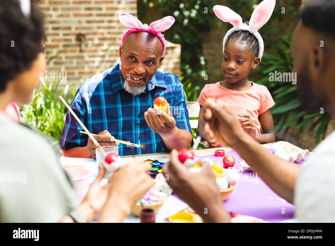 Happy african american family coloring easter eggs in garden Stock ...