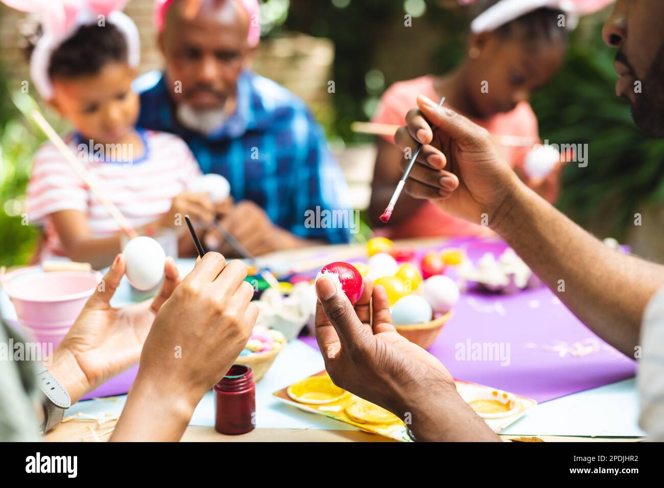 Happy african american family coloring easter eggs in garden Stock ...
