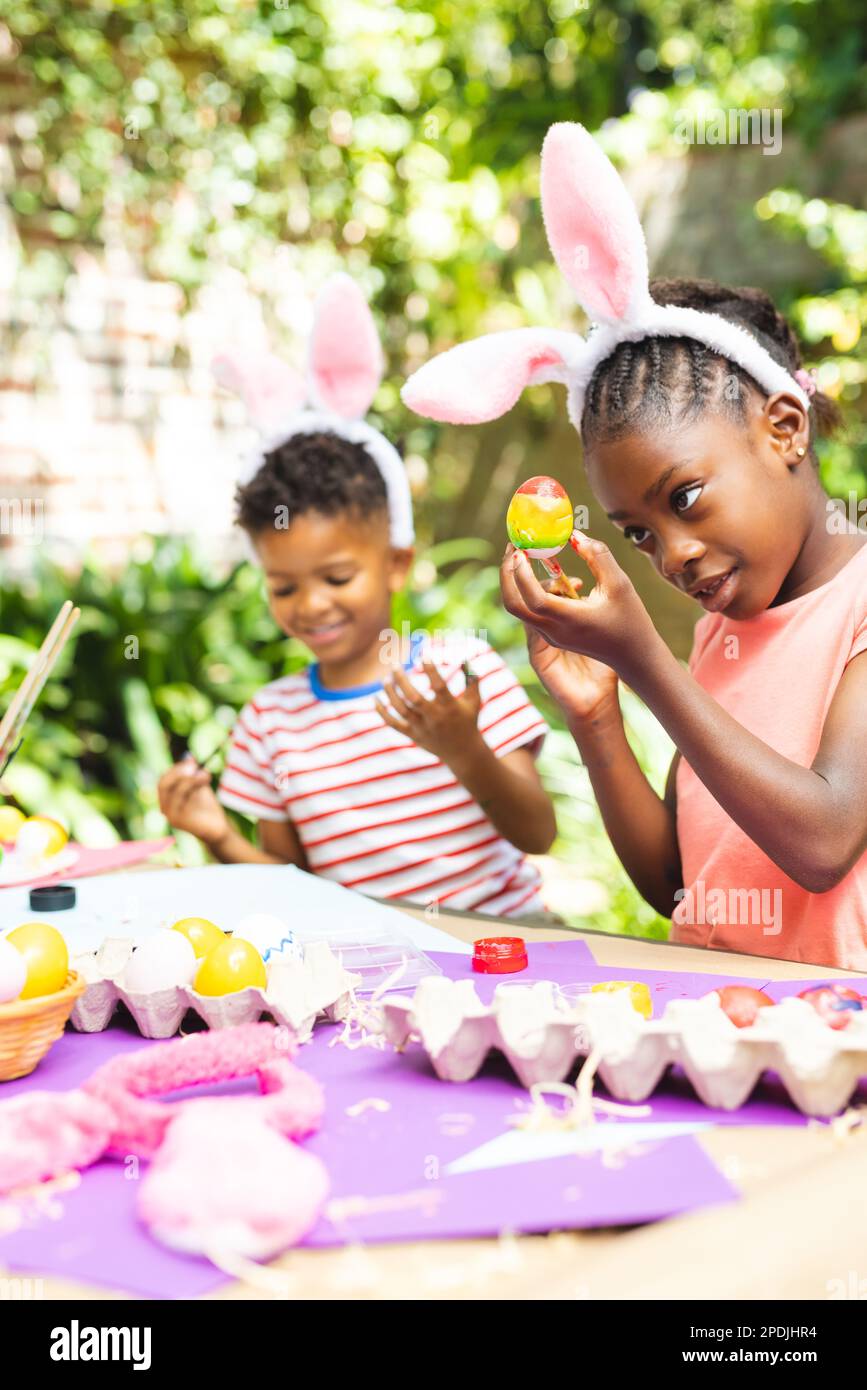 Happy african american children coloring easter eggs in garden Stock ...