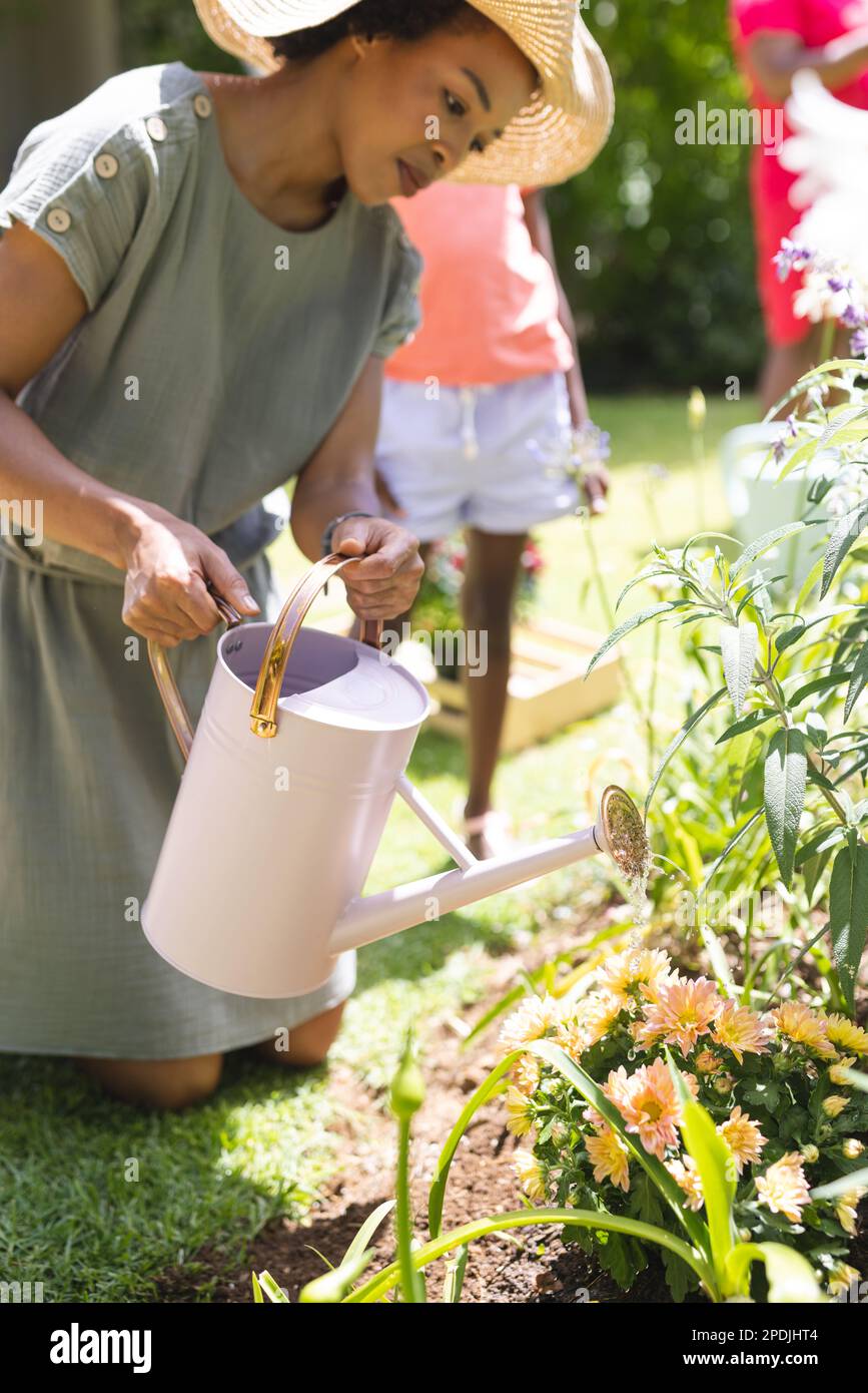 Happy african american family watering plants in garden Stock Photo - Alamy