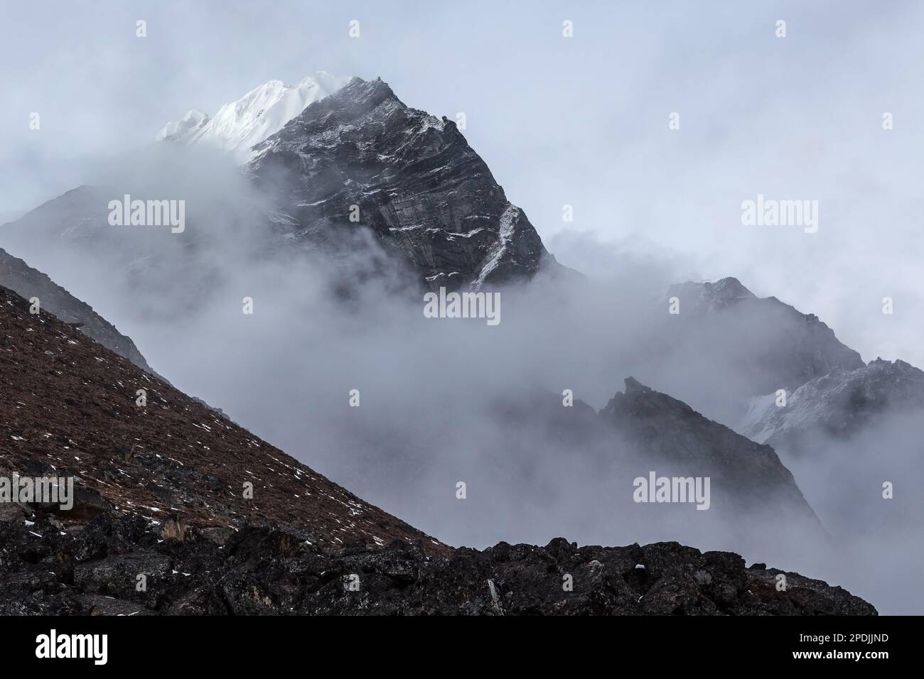 Dramatic black rock in mist on the famous Everest Base Camp Trek in the ...