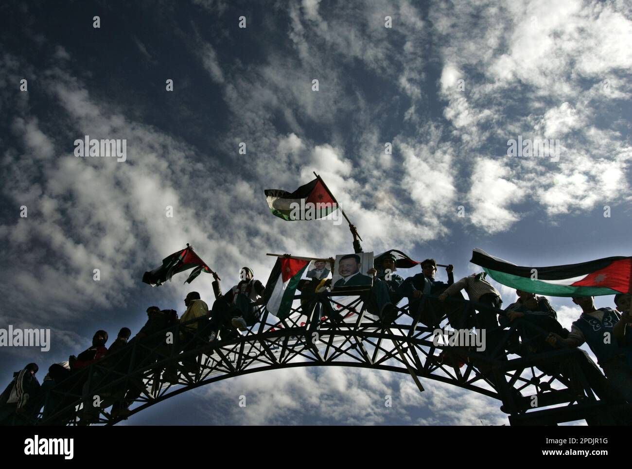 Jordanians hold Jordanian flags and pictures of King Abdullah II as the ...