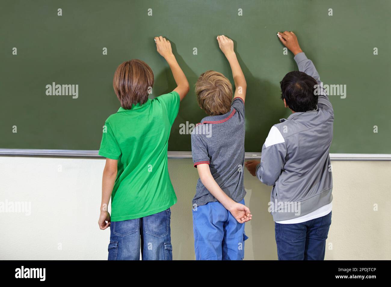 The best way to learn. three children writing on a black board Stock ...