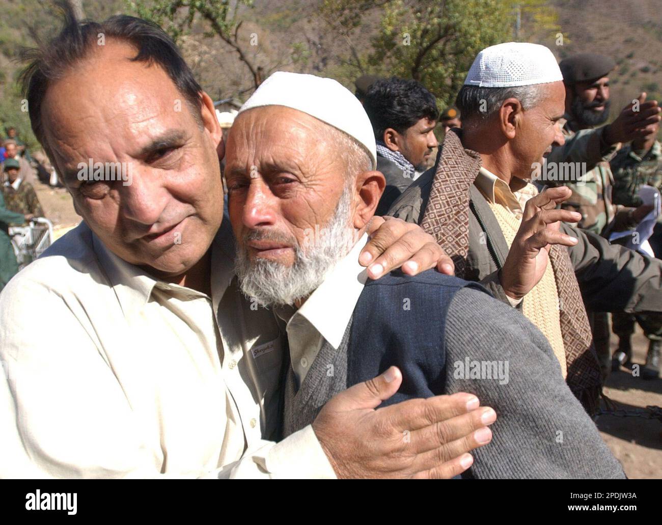 An old Kashmiri man, an earthquake survivor, hugs his relative before ...