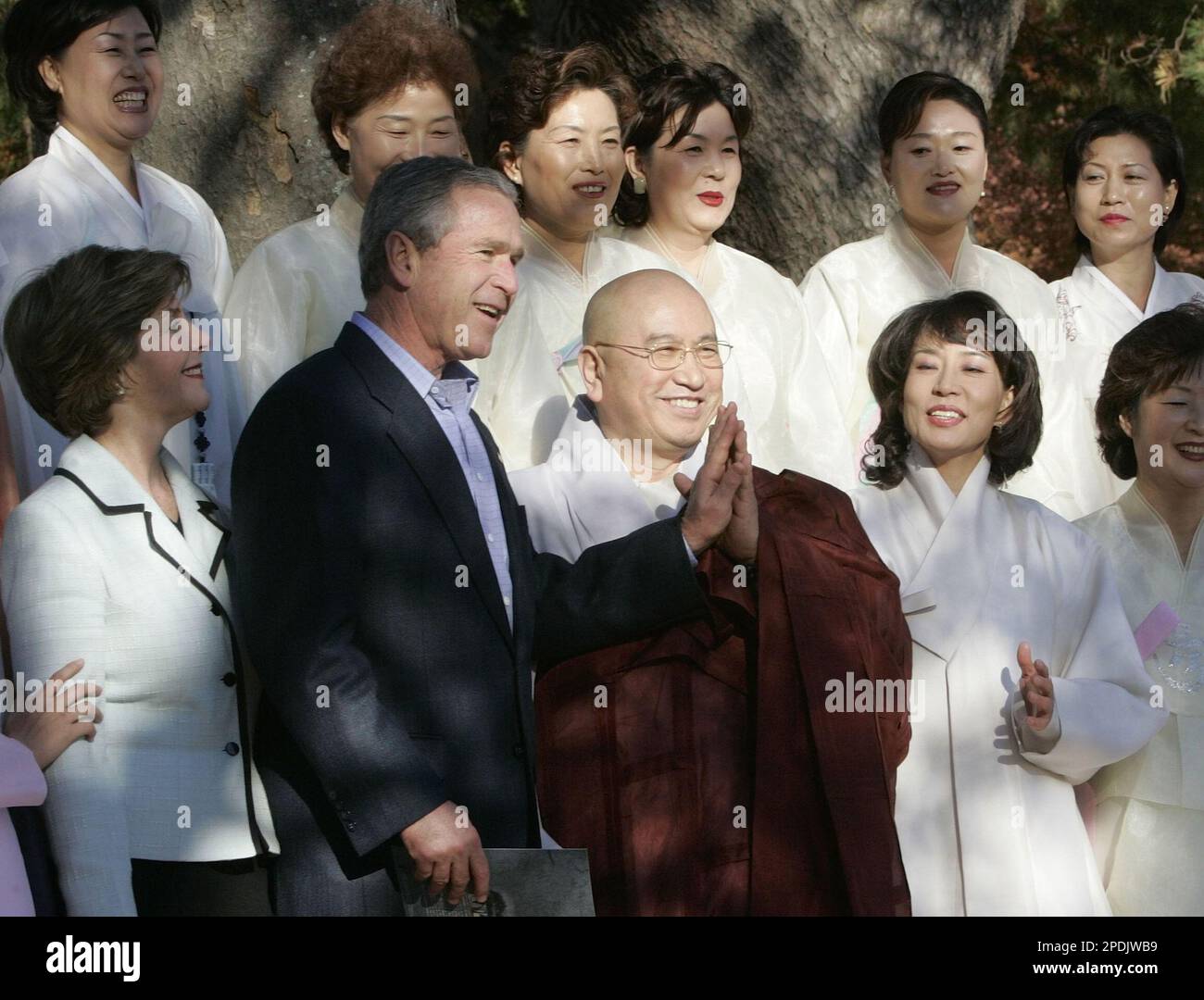U.S. President George W. Bush, second from left, touches hands with ...