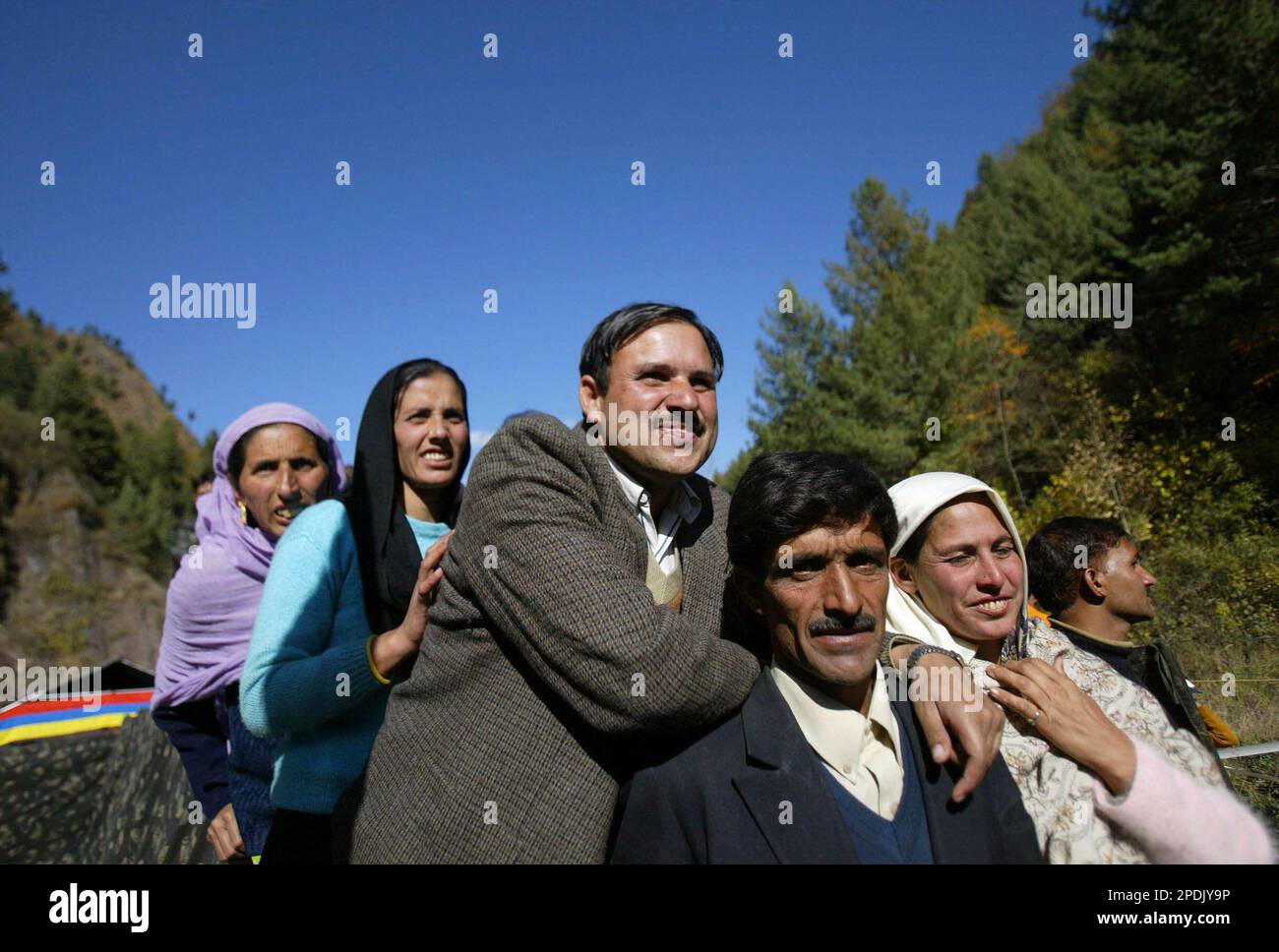 An Indian Kashmiri family watch their relatives on the Pakistani side ...