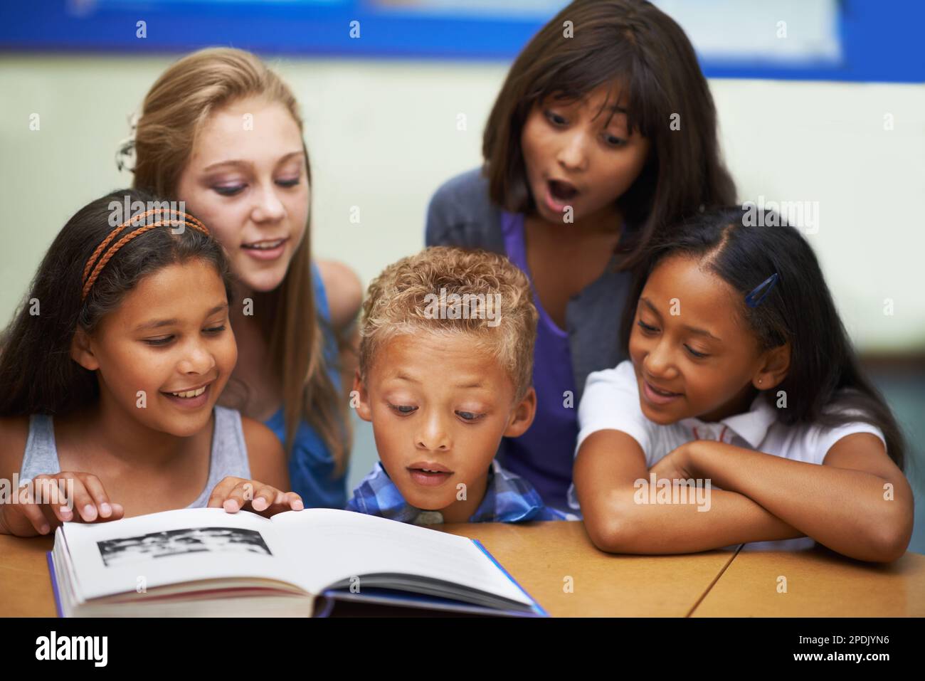 Getting our learn on. A group of students looking through a textbook ...
