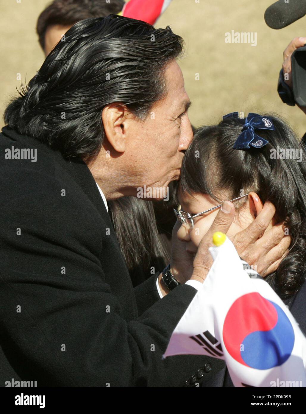 Peru's President Alejandro Toledo kisses a South Korean girl during a ...