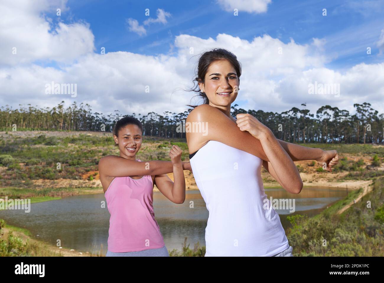 Warming up before the jog. Two young woman stretching in anticipation ...