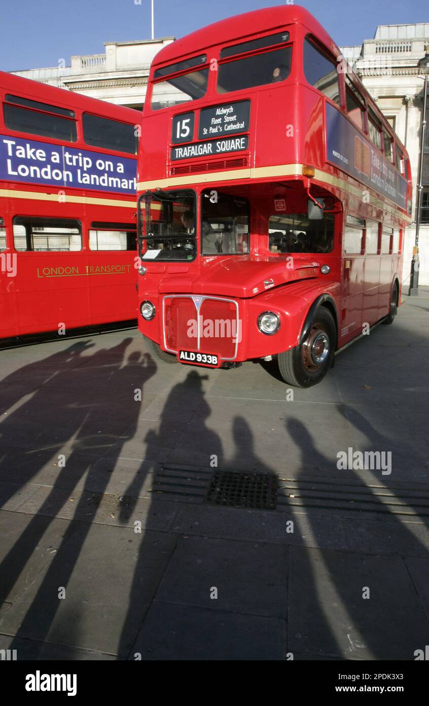 Shadows of people are seen around two Routemaster London Buses parked ...