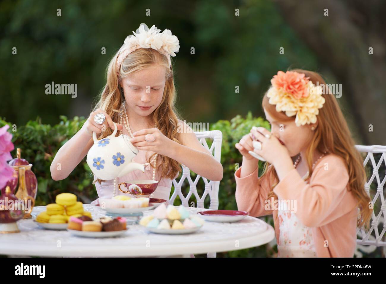 Having a make-believe tea party. Two young girls having a tea party in ...