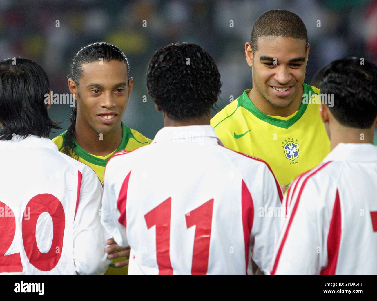 Brazil's Ronaldinho, left, and teammate Adriano greet the players of ...
