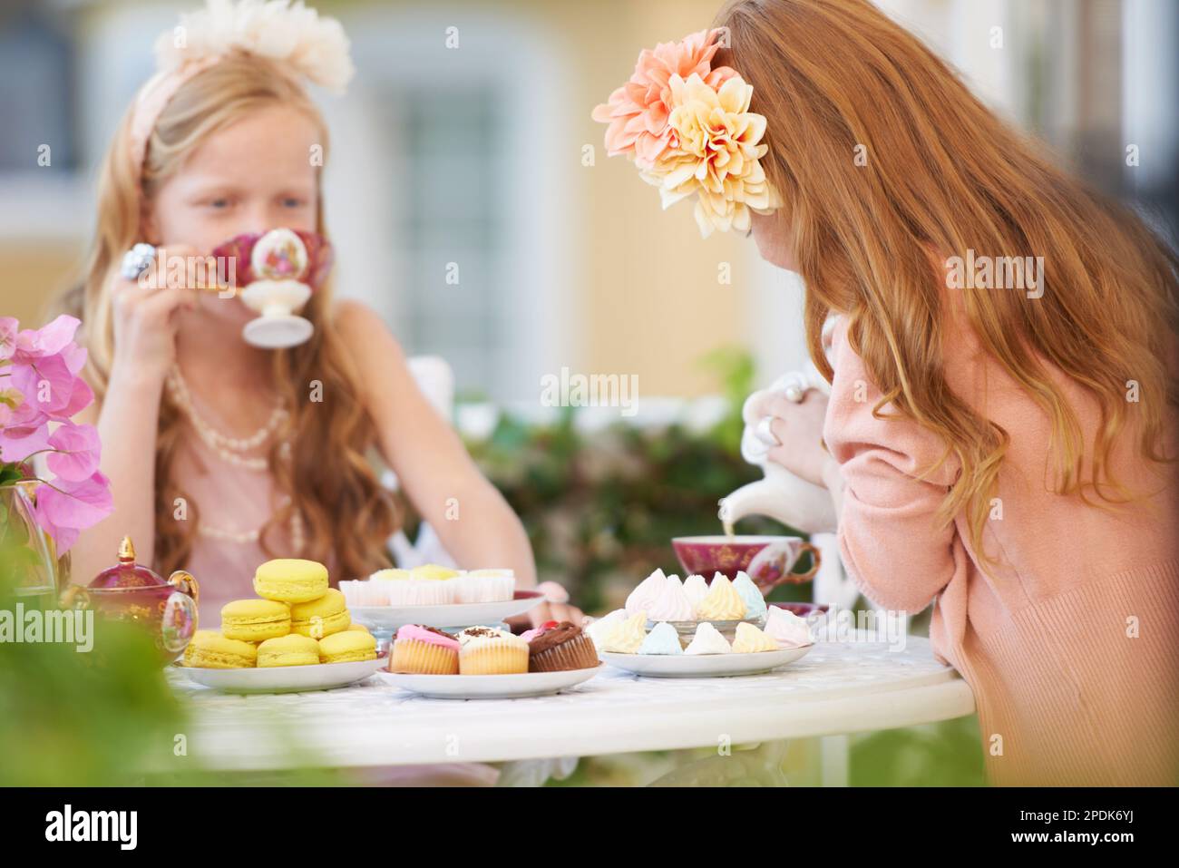 Having a make-believe tea party. Two young girls having a tea party in ...