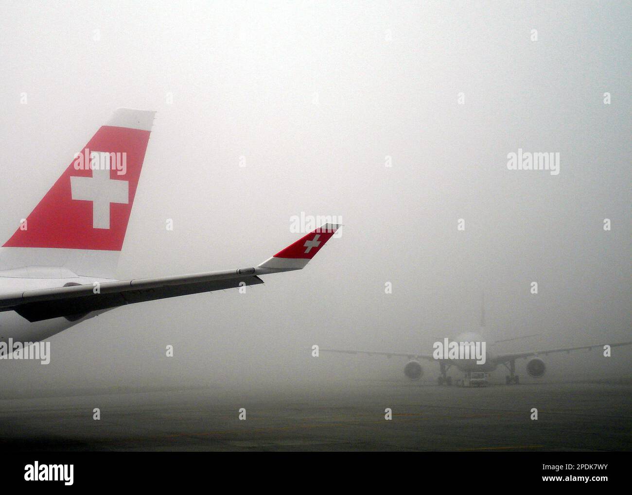 An aircraft by airline Swiss gets ready to take off as another sits at ...