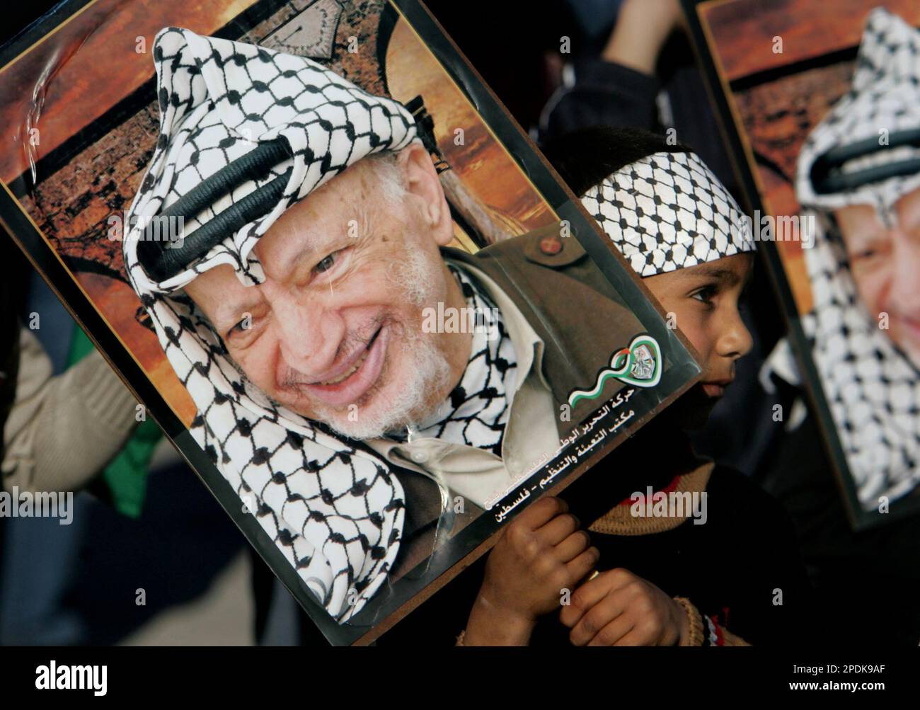 A boy holds a portrait of the late Palestinian leader Yasser Arafat ...
