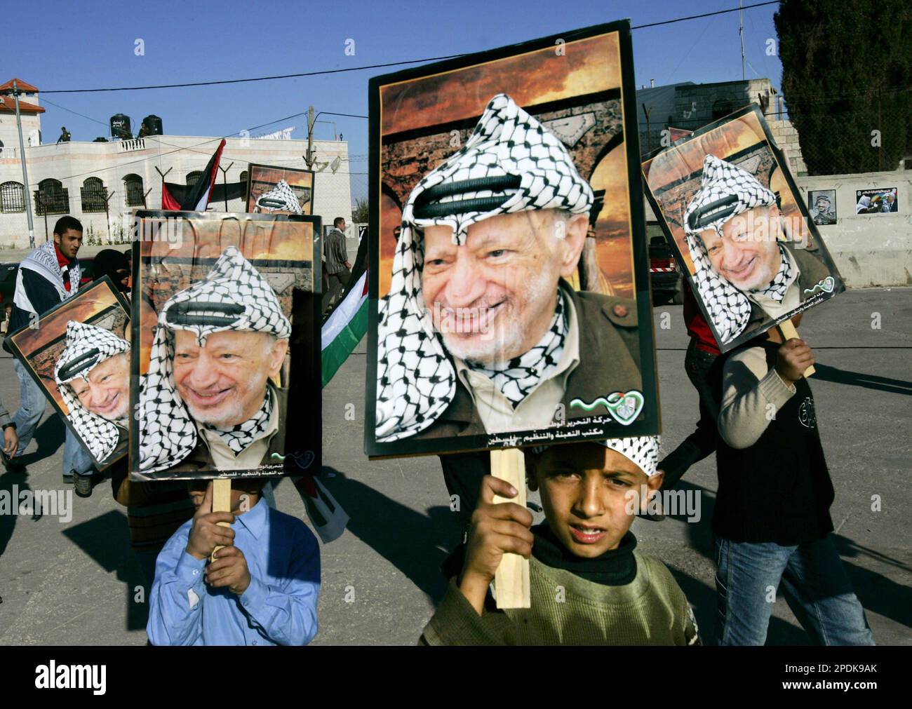 Palestinians hold posters of the late Palestinian leader Yasser Arafat ...