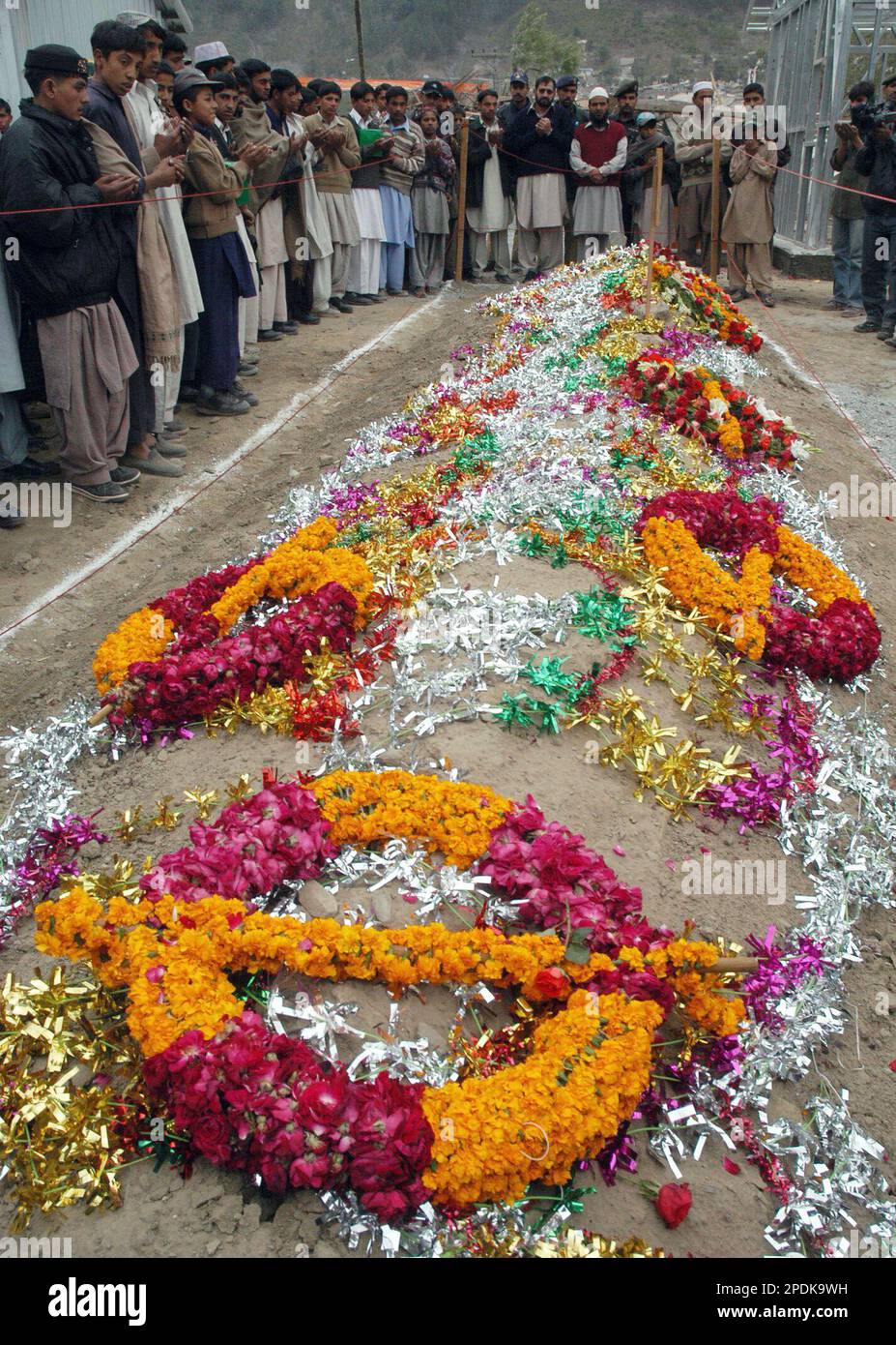 Pakistani students of Balakot High School pray on the mass-grave of ...